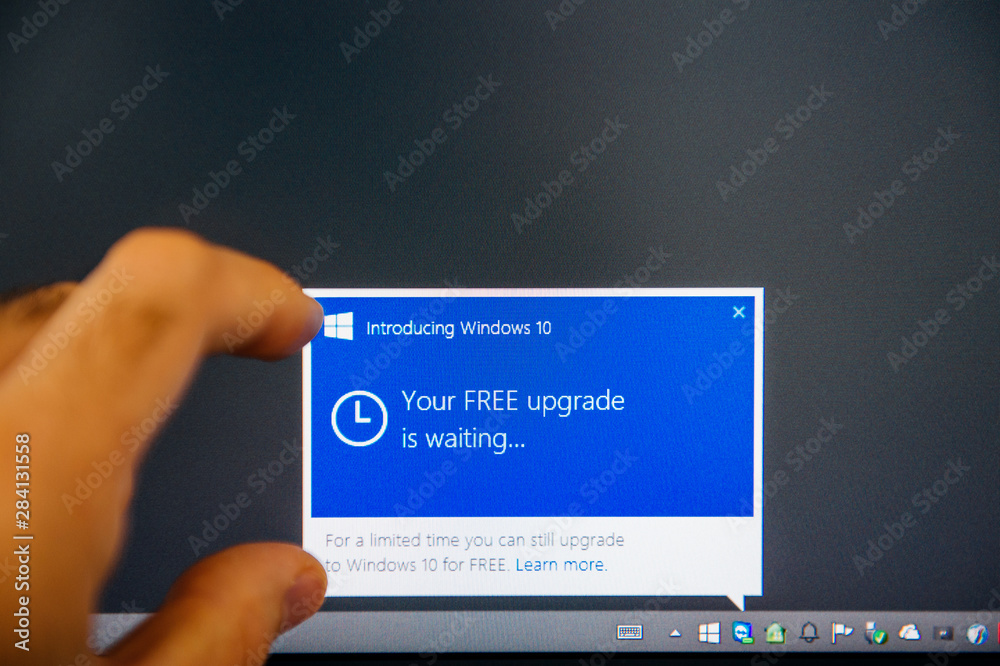 Stockfoto PARIS, FRANCE - AUG 5, 2015: Introducing Windows 10 - Man touching display with ...