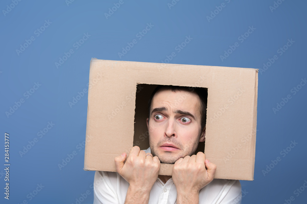 Scared guy with box on head, shocked, despair, grimace, front view ...