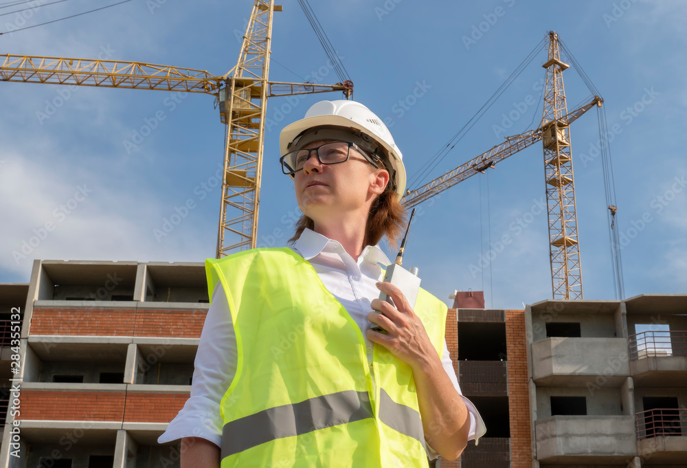Portrait of woman engineer on background of under construction ...