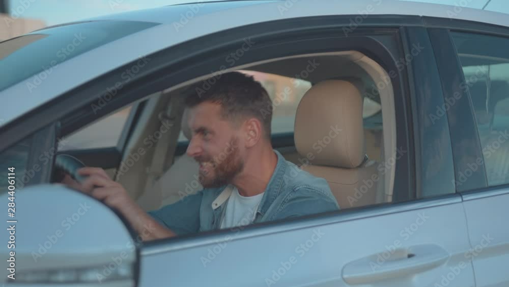 Aggressive young man driver is stuck in the car hitting leaning on ...