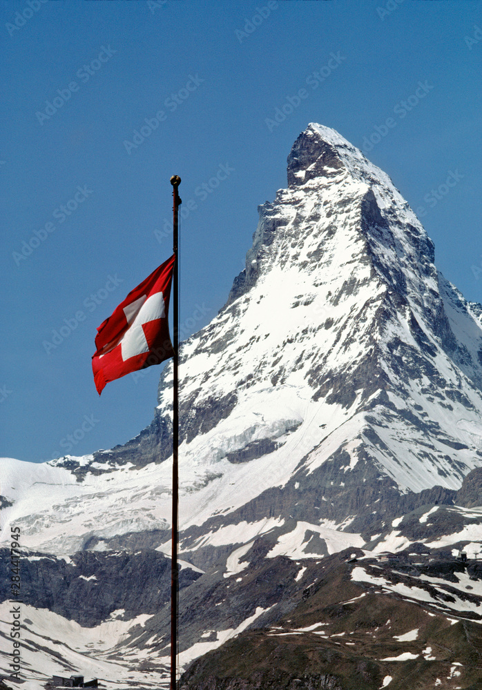 Switzerland, Matterhorn. The Swiss flag flies proudly at the base of ...