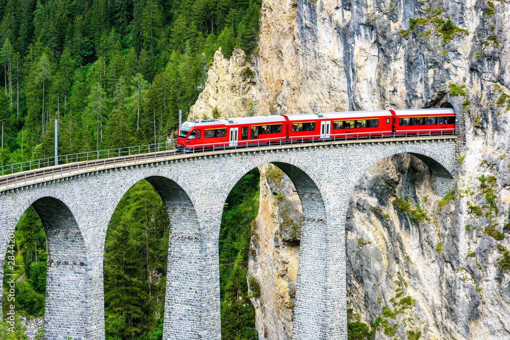 Red express train runs on Landwasser Viaduct, Switzerland. It is famous ...