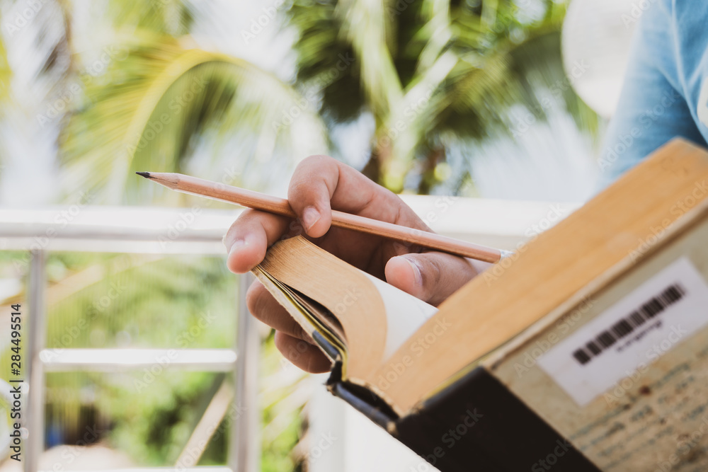 Student reading a old book. Sitting at terrace home in autumn forest ...