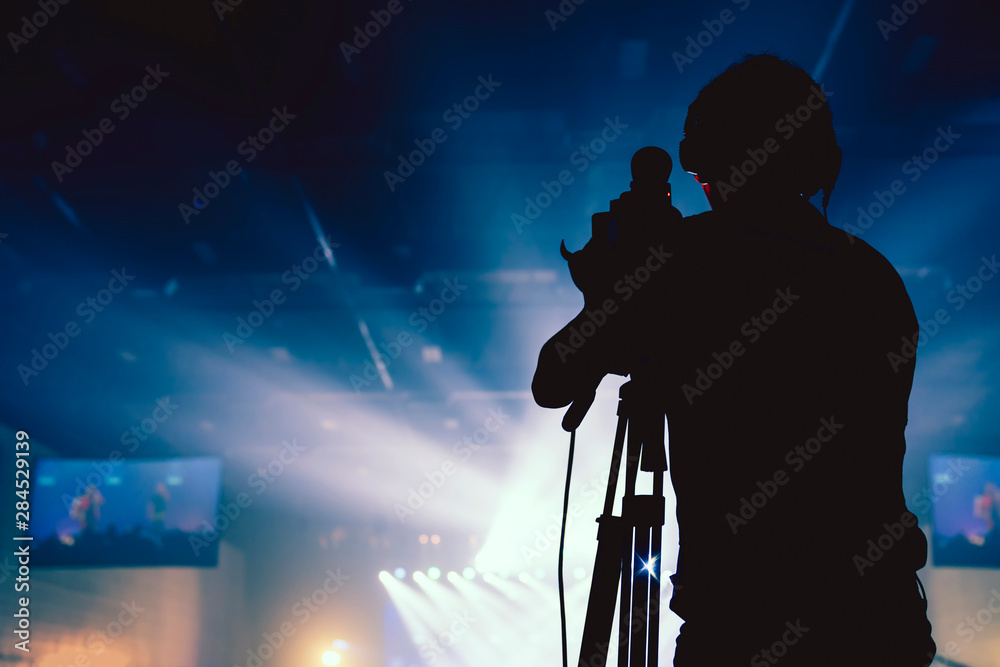 silhouette camera man standing record live concert with smoke and light ...