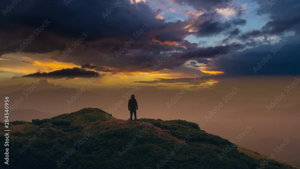 The man standing on a mountain against a picturesque cloud stream. time ... The man standing on a mountain against a picturesque cloud stream. time ...