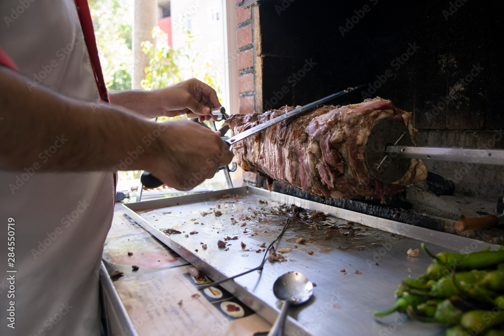 Chef prepares a traditional Turkish cag kebab at an open restaurant in ...