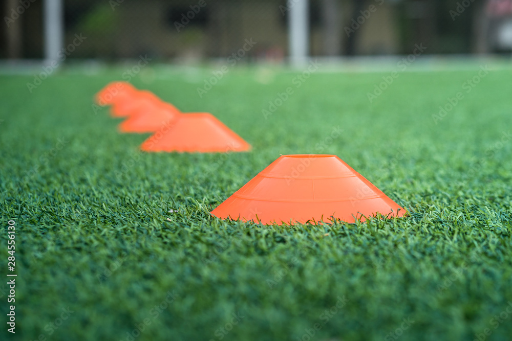 Football training cone is aligned on artificial grass pitch, ready for ...