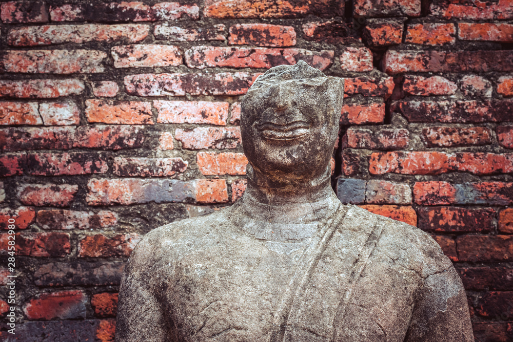 Buddhist smile statue. Crumbling statue with broken-off upper half of ...