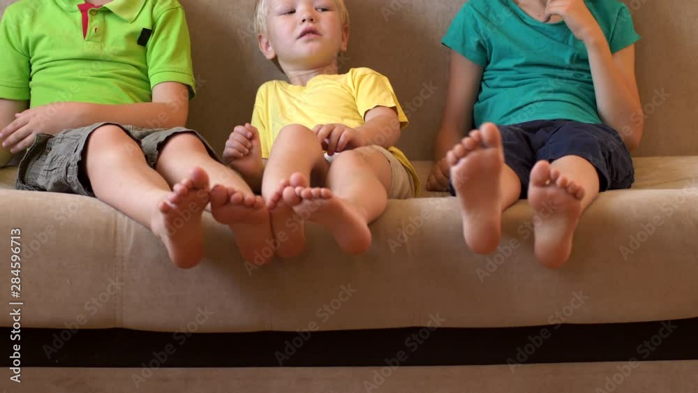 Active funny kids play with each other. Children pushing their feet ...