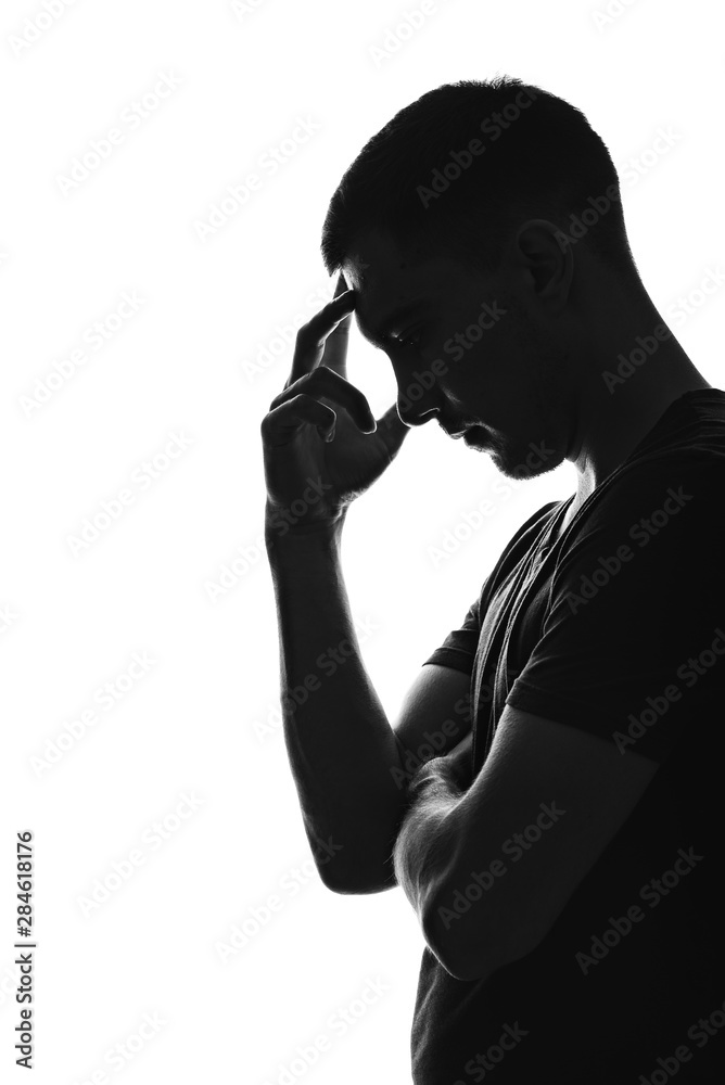 Silhouette portrait profile of a thinking young man holding his hand to ...