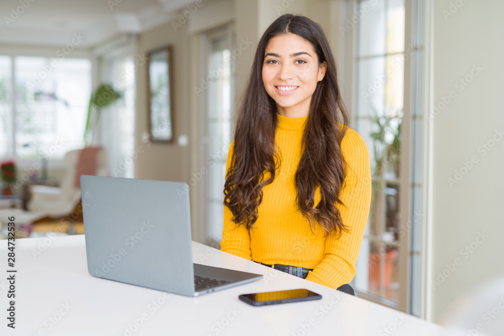 Young woman using computer laptop with a happy and cool smile on face ...