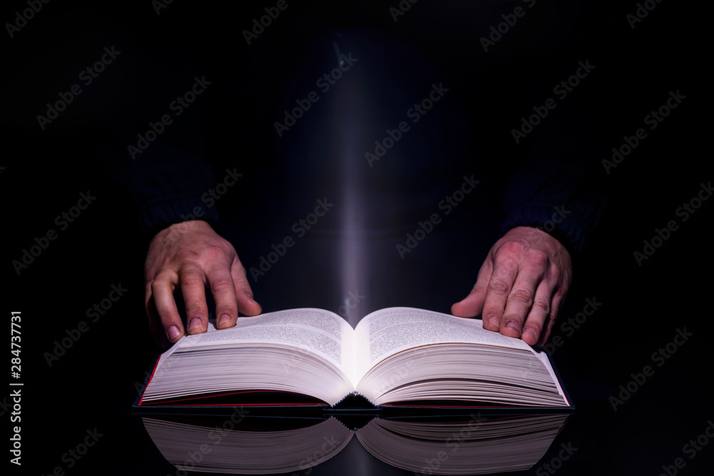 Person reading book with glowing light coming from inside of it. High ...