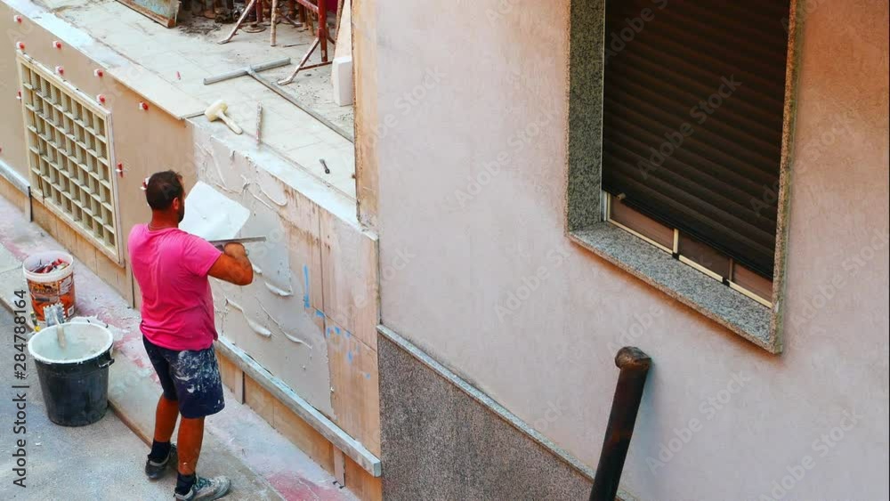 Worker labor building wall and UPVC groove line with plaster cement at ...