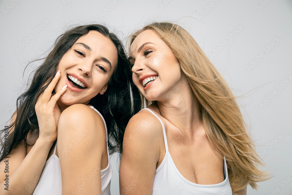 Natural beauty young women in white tank tops smiling standing back to ...