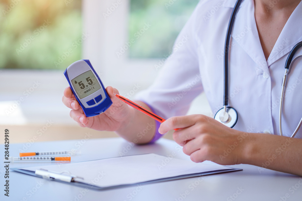 Doctor shows glucose meter with blood glucose level to diabetes patient ...