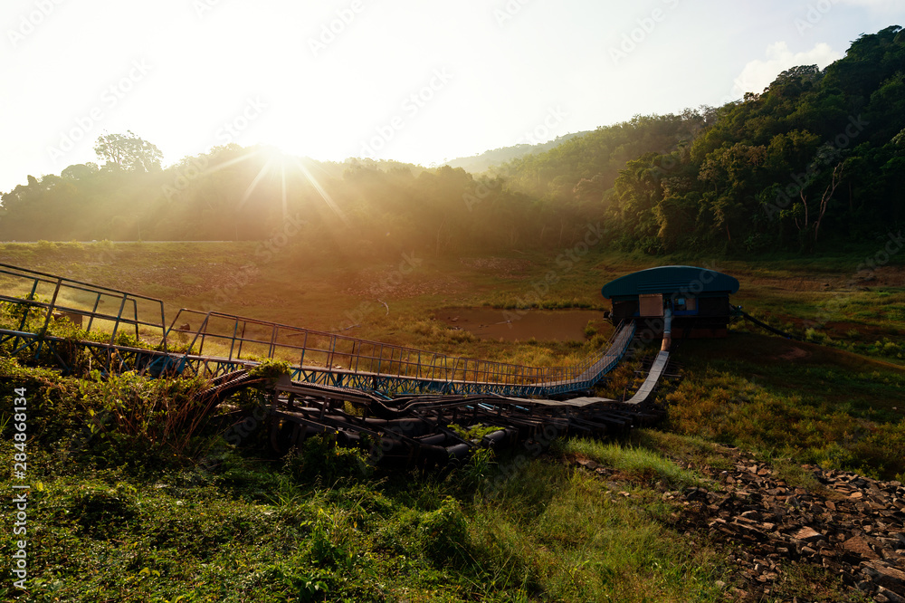 Sunrise at dry dam..Floating pump laying on the bottom ground of bang ...