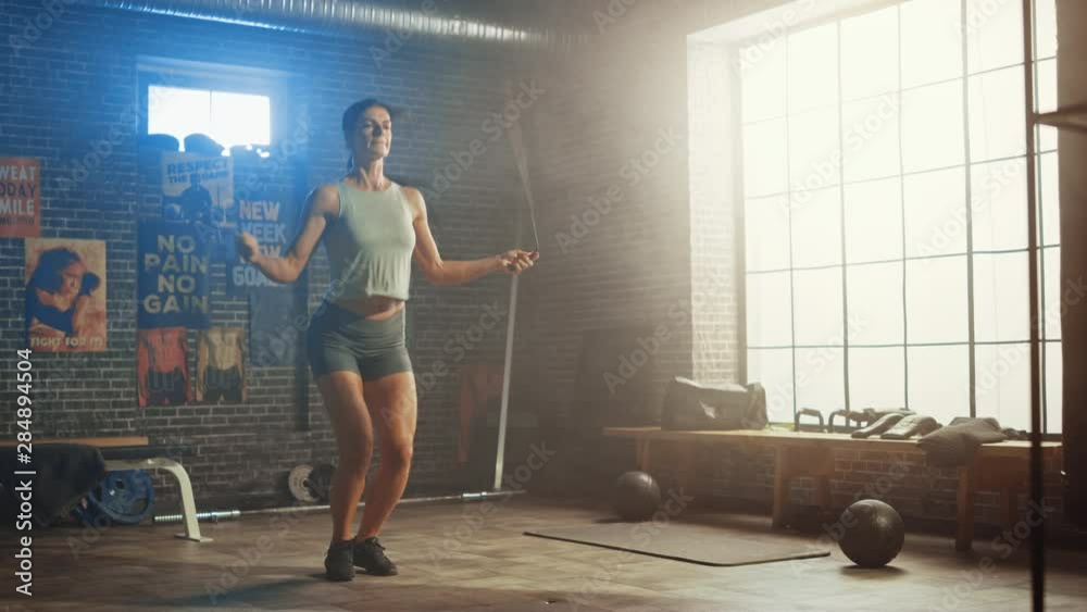 Vidéo Stock Strong Athletic Woman Exercises with Jumping Rope in a Loft ...