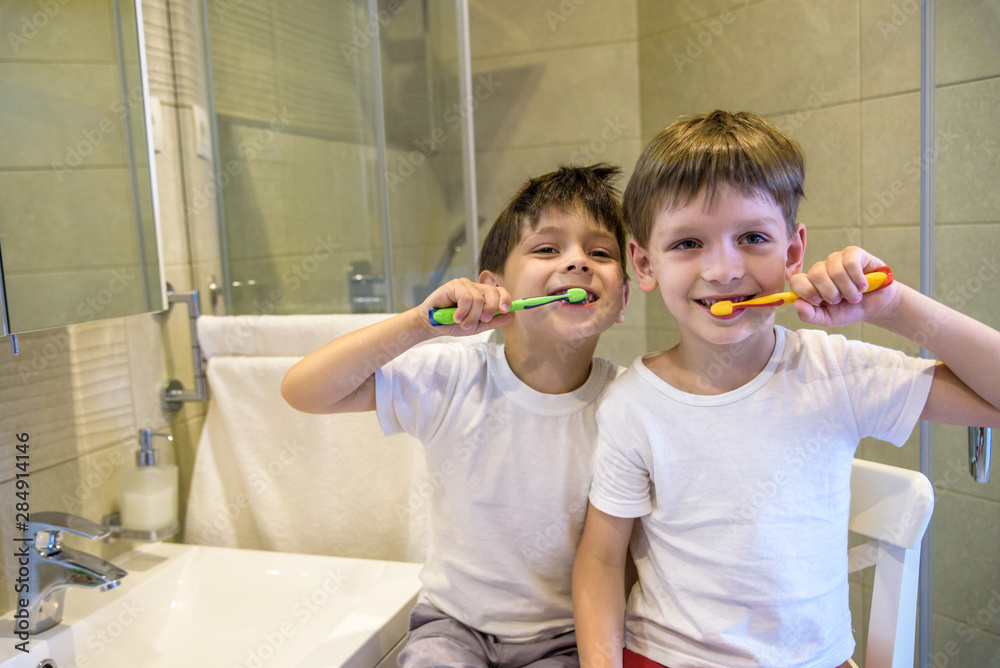 Closeup portrait of twins kids toddler boy brother in bathroom toilet ...