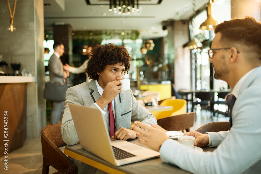 Men are sitting at table in modern cafe. Talk about work Stock Photo ...