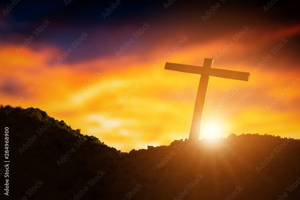 Conceptual wood cross or religion symbol shape over a sunset sky with ...