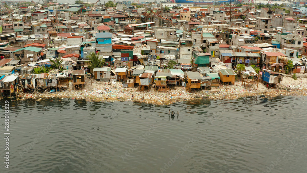 Slums with shacks of local residents and the river bank littered with ...