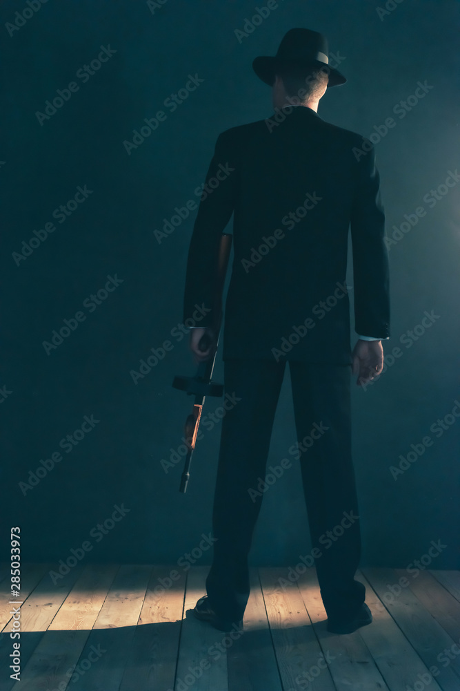 Retro gangster stands with machine gun. Rear view. Stock Photo | Adobe ...
