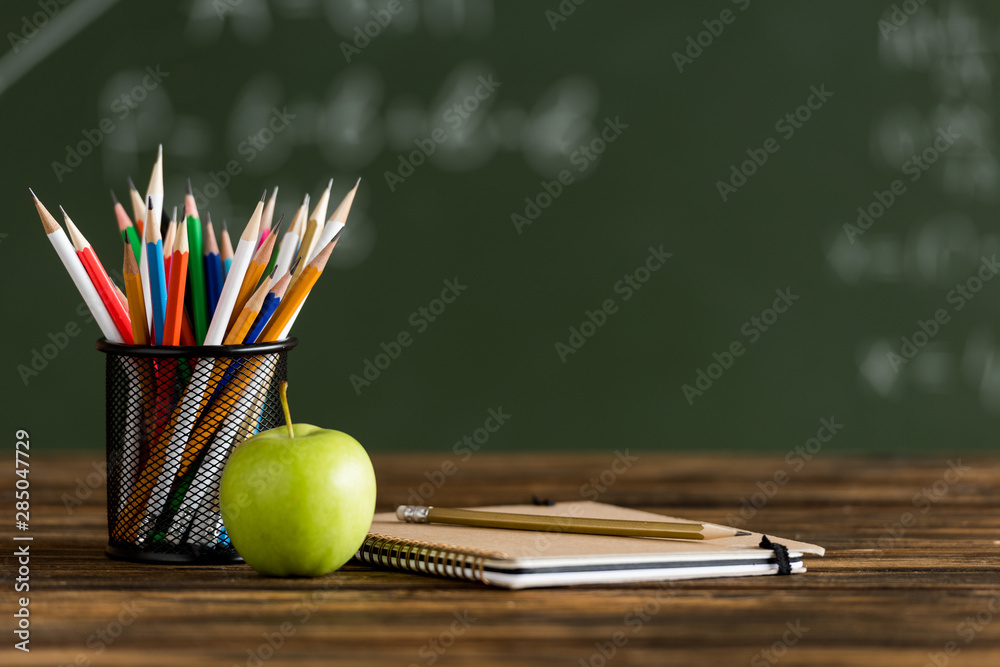 Back to school. Notebook, apple and colored pencil on school table ...