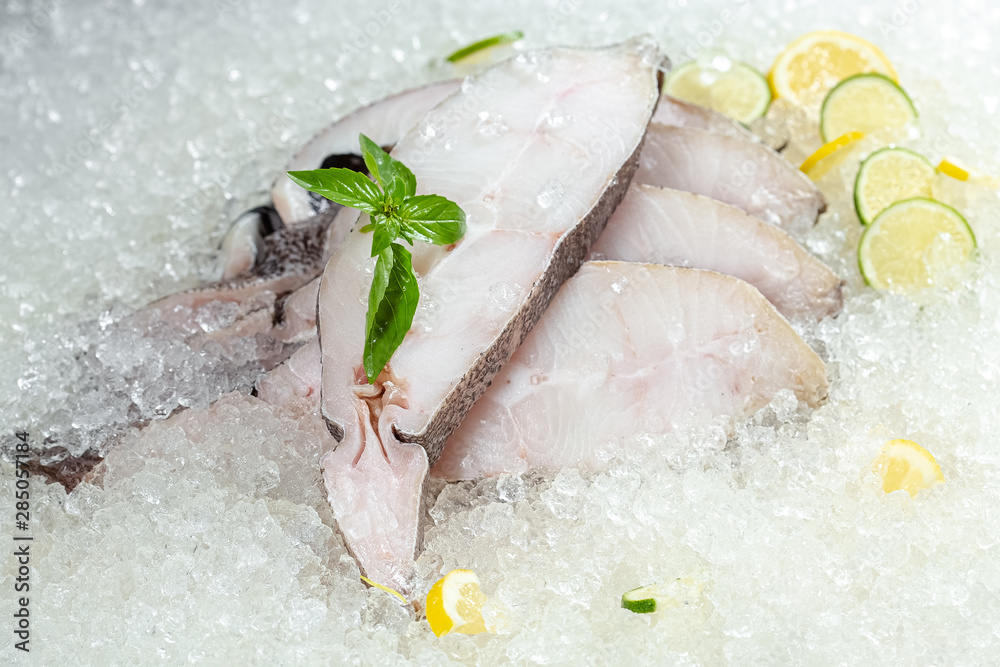 fresh sea ocean white fish sliced in pieces, lying on ice, headless ...