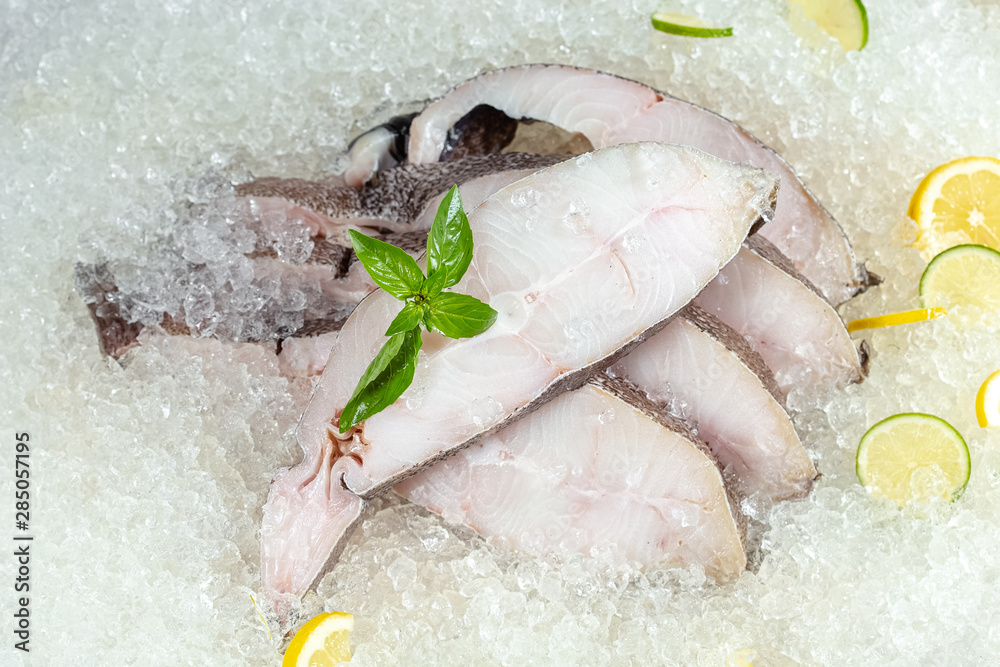 Foto de fresh sea ocean white fish sliced in pieces, lying on ice ...