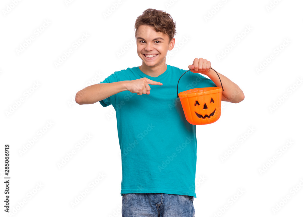 Happy halloween concept. Smiling teen boy holding orange pumpkin bucket ...