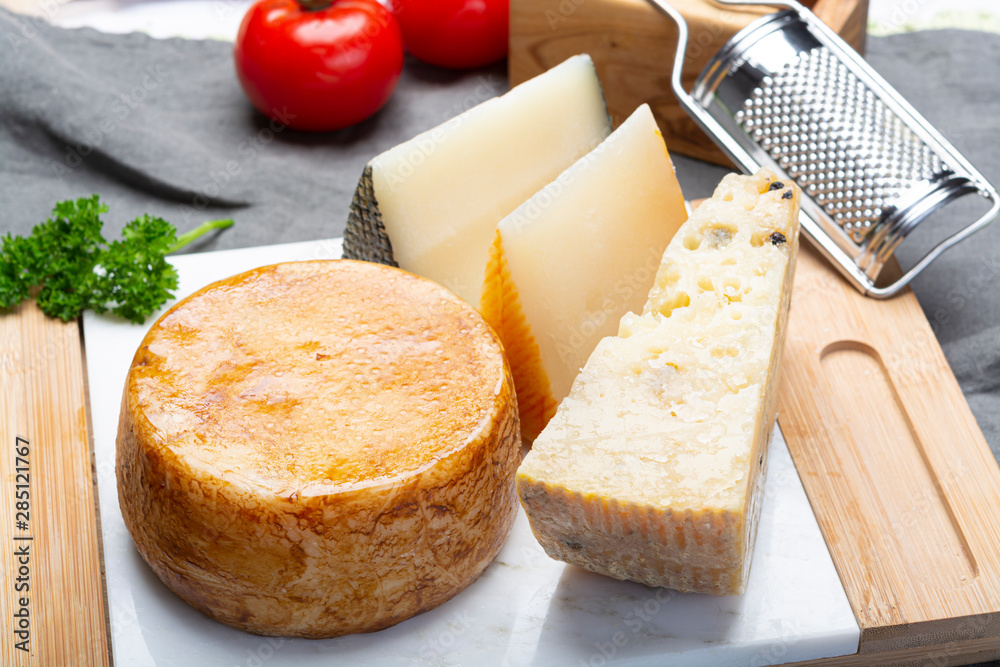 Variety of Italian pecorino cheeses, yellow aged, with black peppers ...