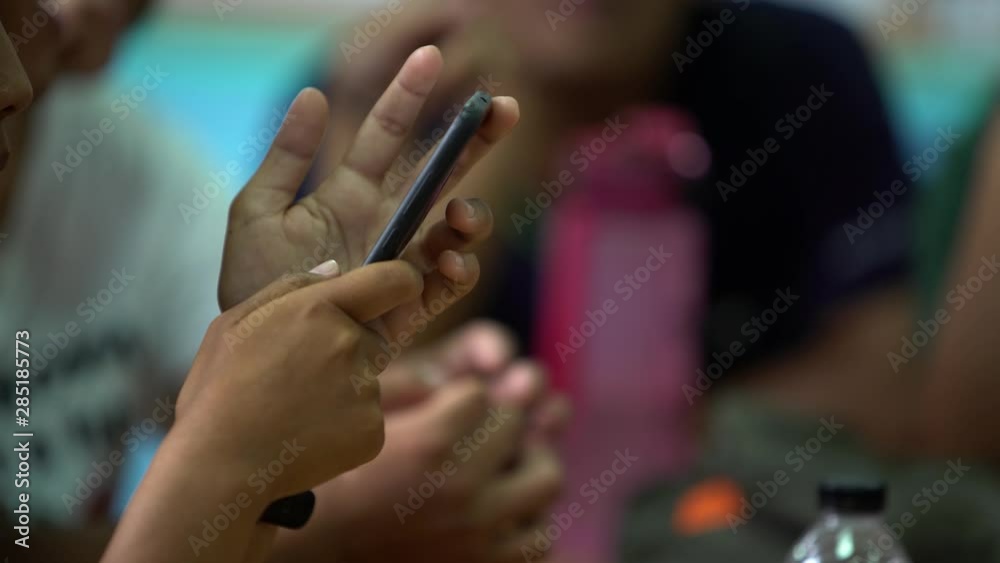 4K Closeup young students are reading a text on phone. Children looking ...