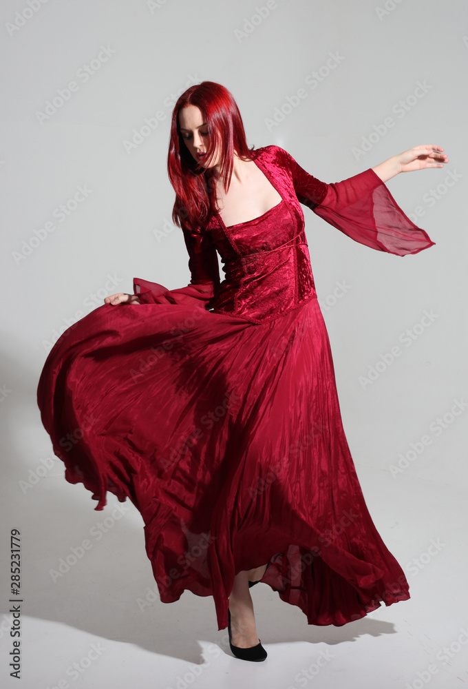 full length portrait of a girl wearing a red medieval fantasy gown ...