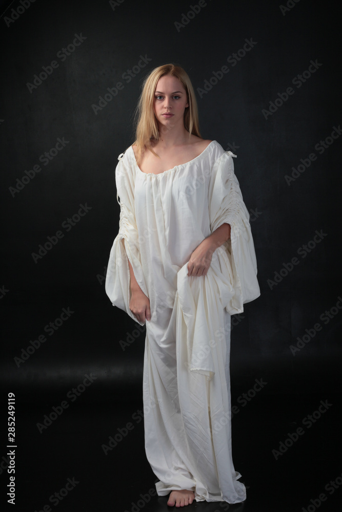 full length portrait of blonde girl wearing long white flowing robe ...