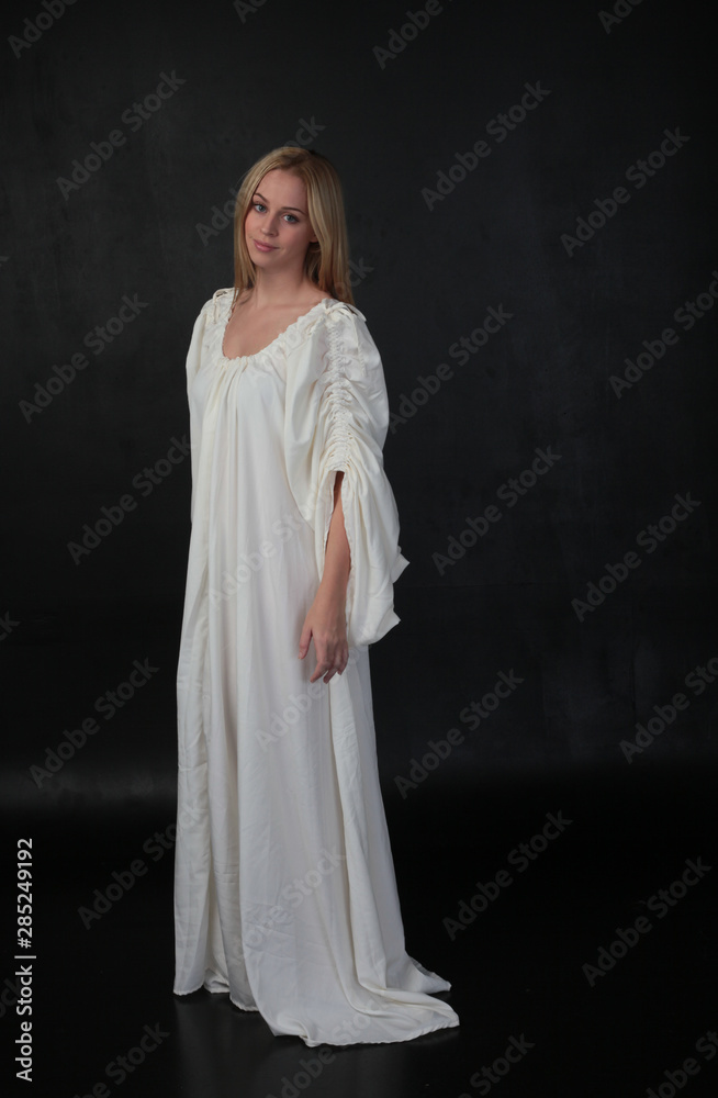 full length portrait of blonde girl wearing long white flowing robe ...