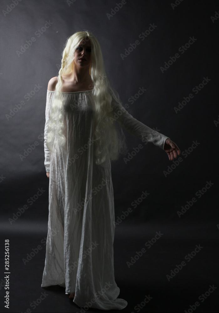 Ghostly full length portrait of a woman with long blonde hair wearing a ...