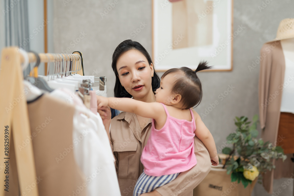 It is not easy to be a working mom! Young beautiful designer working on ...