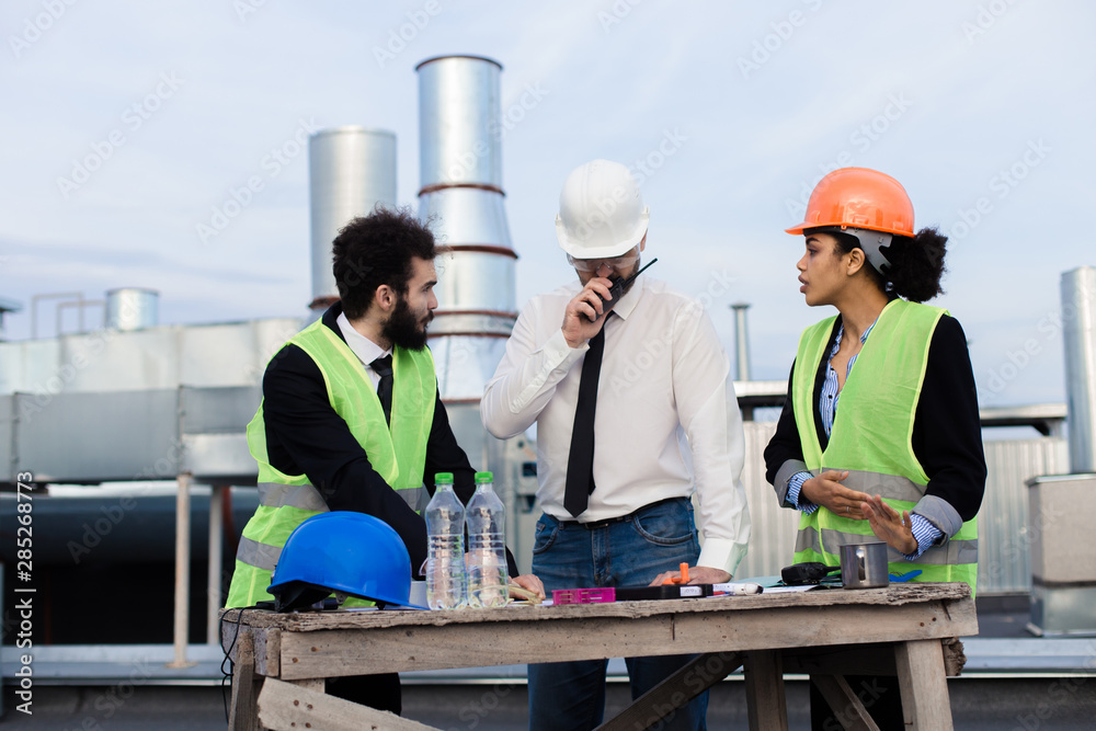 Multiethnic group of workers architect and two engineers have a ...