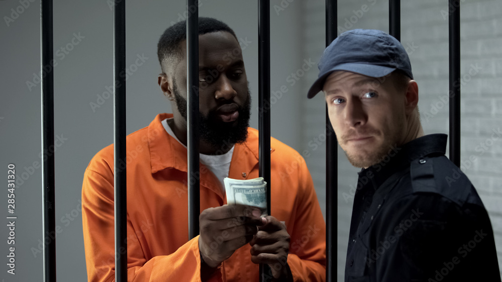 Black imprisoned gangster giving money to prison guard, bribery in jail ...