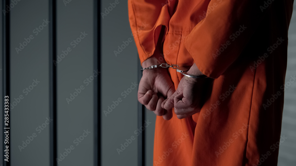 Prisoner with handcuffed arms behind back, another jail transfer ...