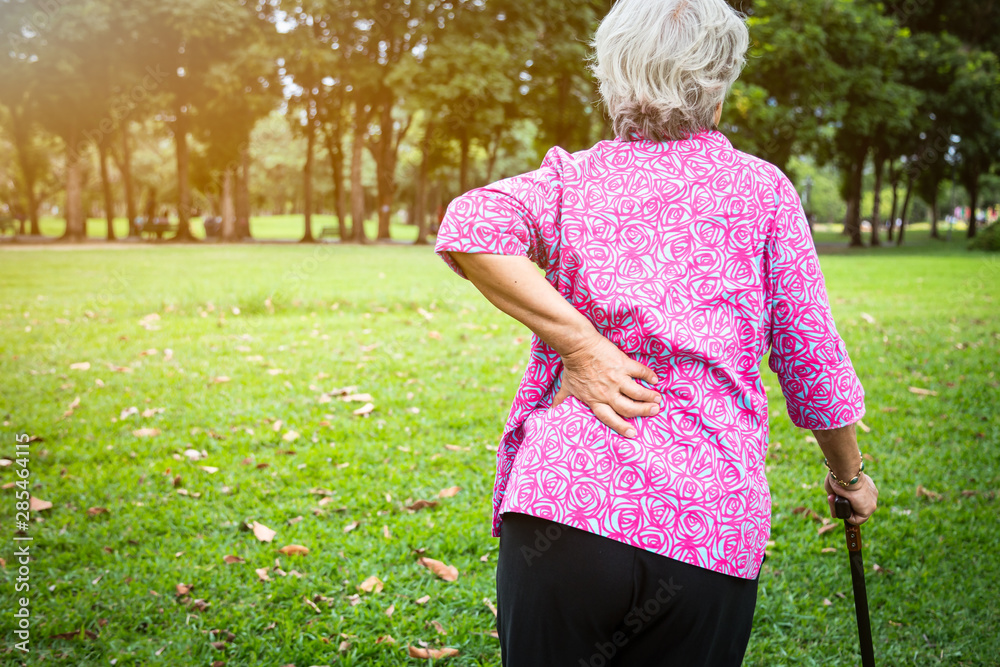 Asian senior hands touching back pain while walking in nature,female ...