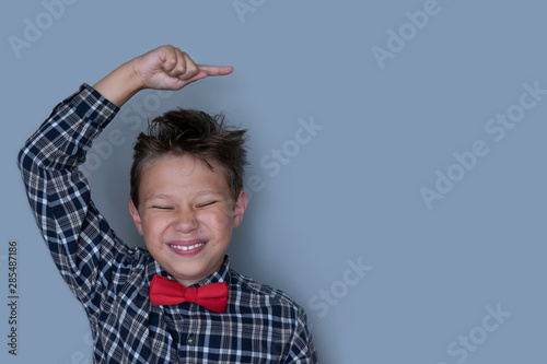 Young schoolchild pointing up portrait. Preteen schoolboy with glasses ...
