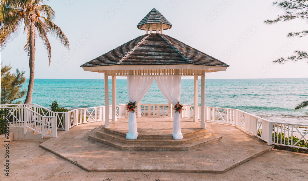 Wedding pavilion on beach. With drapes and flowers and ocean sea ...