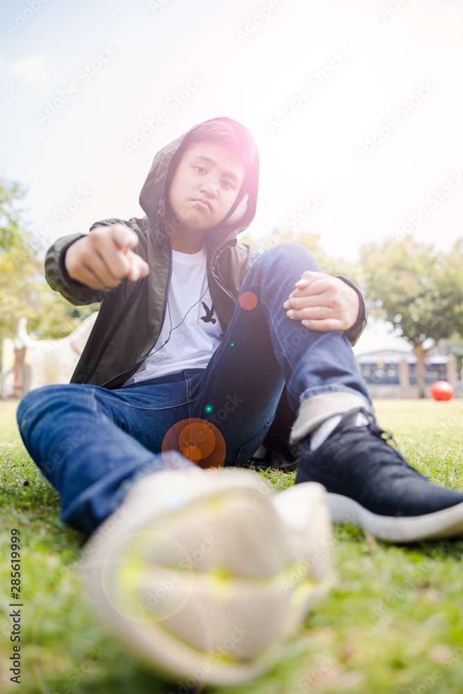 perspective angle view teenager boy sitting and posing point holding ...
