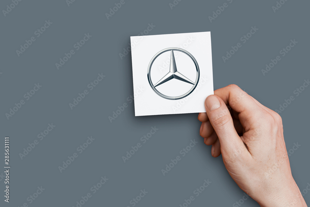 LONDON, UK - October 26th 2018: Hand holding a Mercedes Benz logo ...