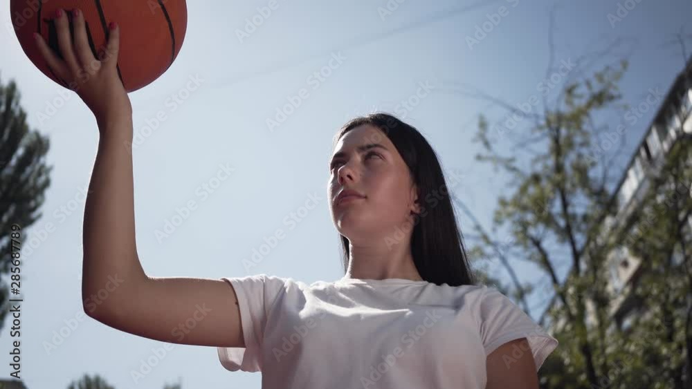 Portrait of cute young brunette woman throwing the ball up. Concept of ...