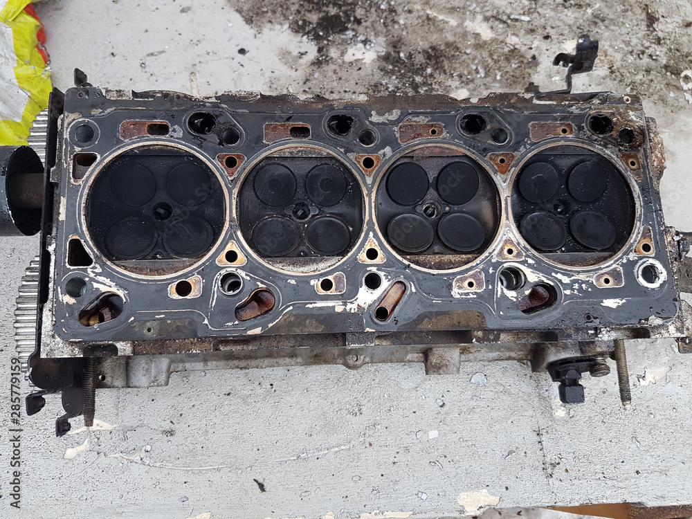 Old car parts. Disassembled engine. The cylinder head of the car engine ...