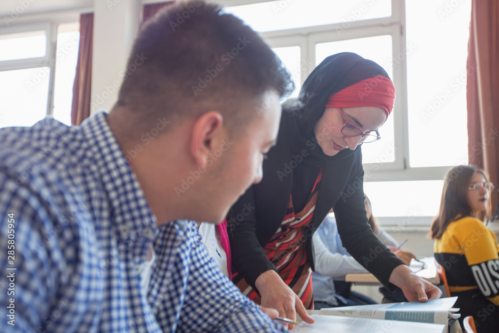 Female muslim professor explain lesson to students and interact with ...