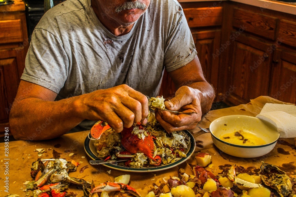 Older man with very strong looking hands eating a crab at a seafood ...