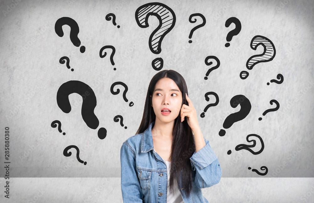Question Marks with young woman in a thoughtful pose.Asianl woman with ...